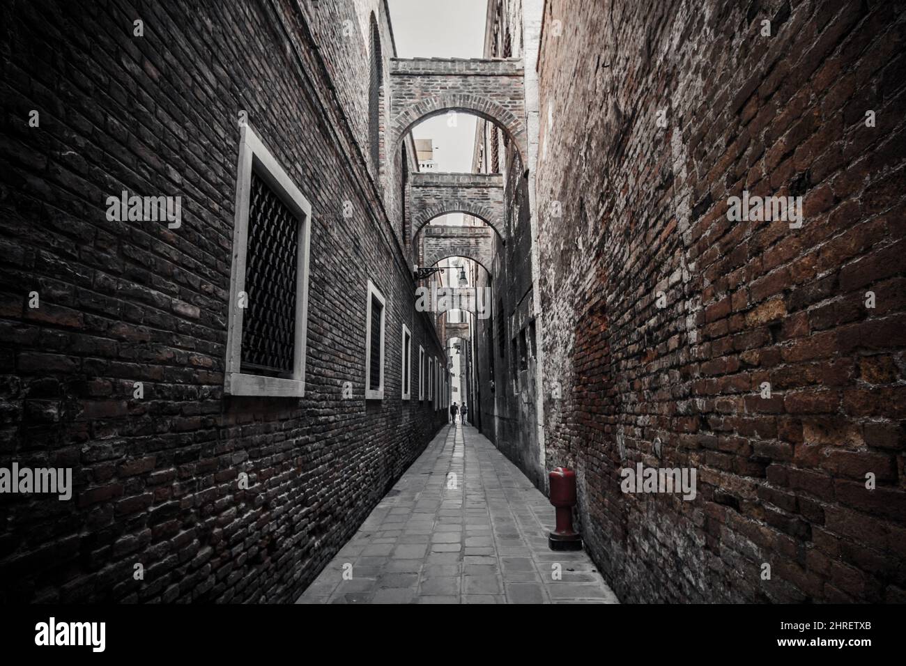View of the narrow long street surrounded by buildings Stock Photo - Alamy