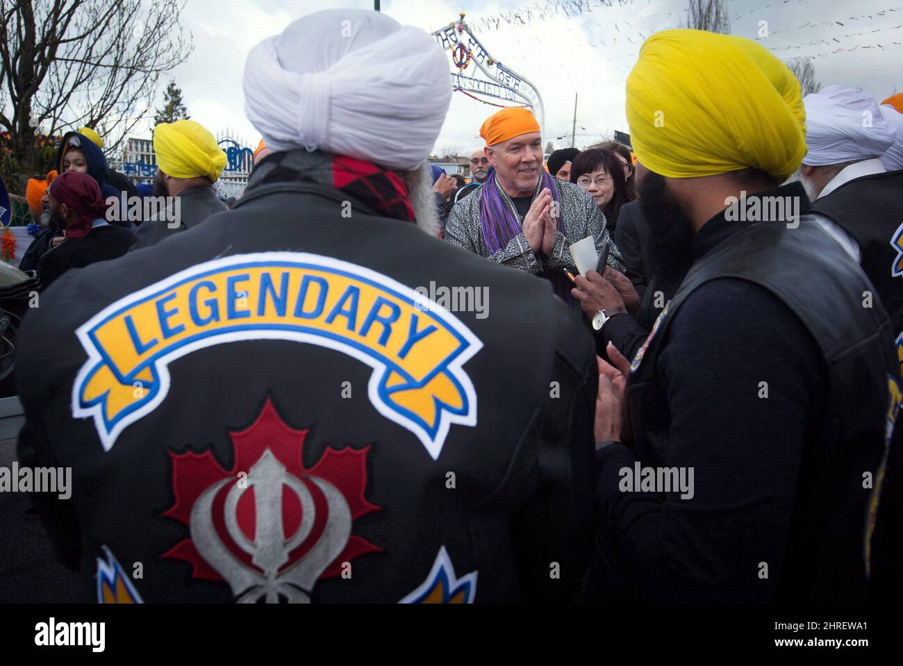 B.C. NDP Leader John Horgan, back, greets members of a Sikh motorcycle ...