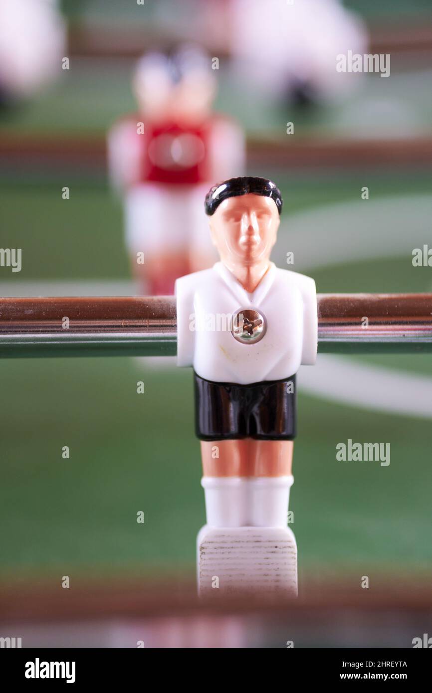 Vertical shot of a figure of a table soccer player in white and black ...