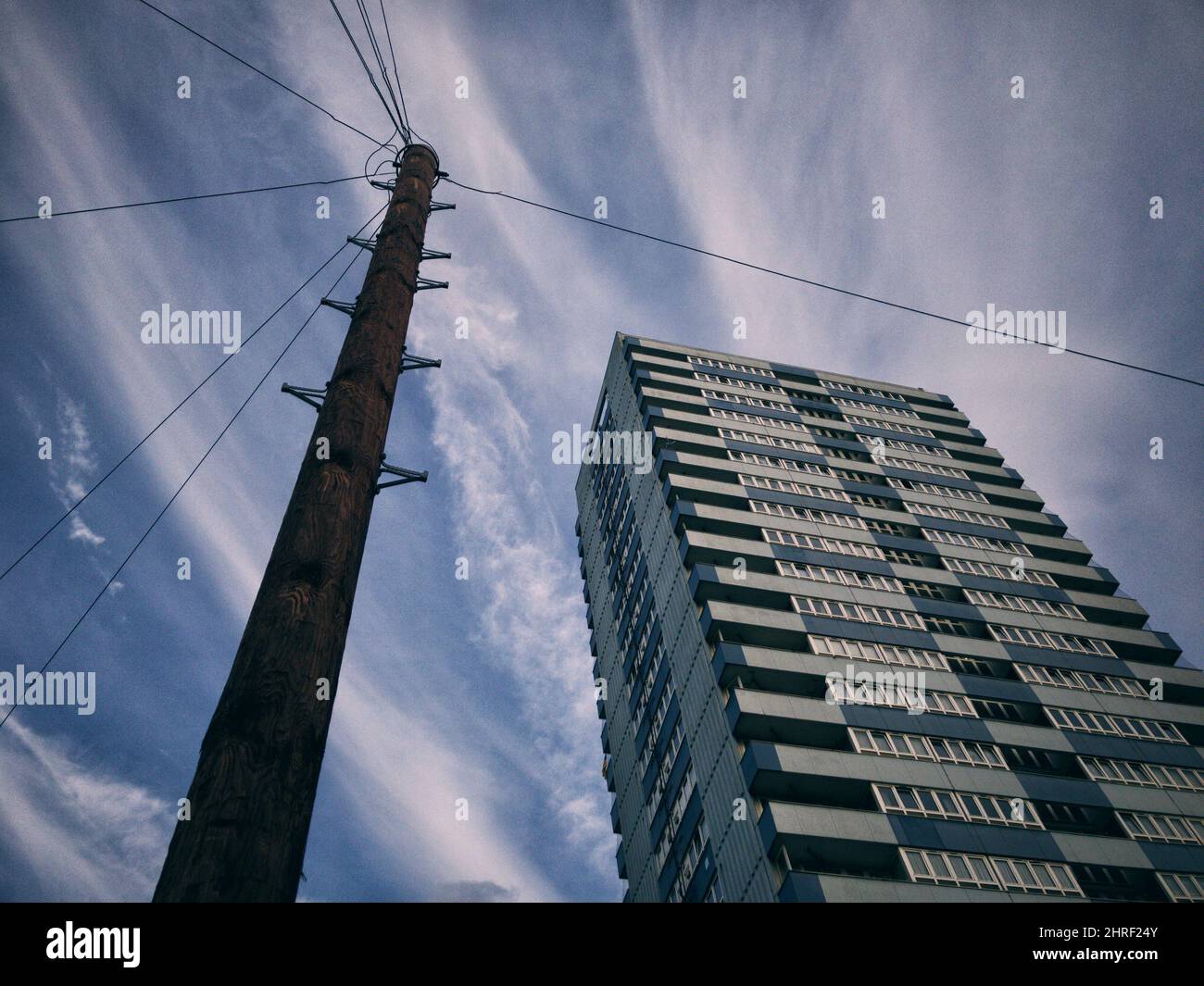 Low angle shot of high-rise building and wooden electric pole Stock ...