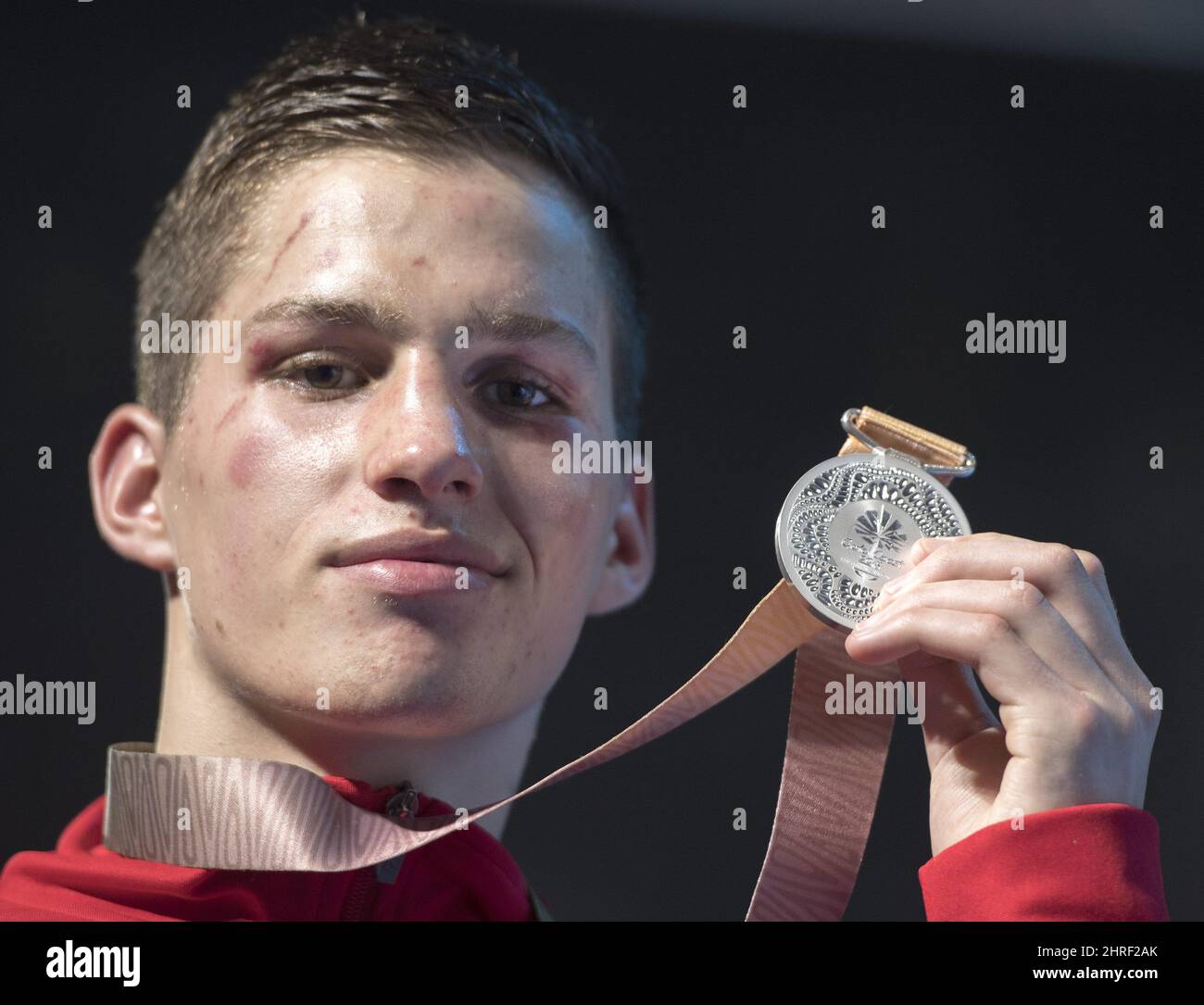 Canada's Thomas Blumenfeld holds up his silver medal after his 64kg ...