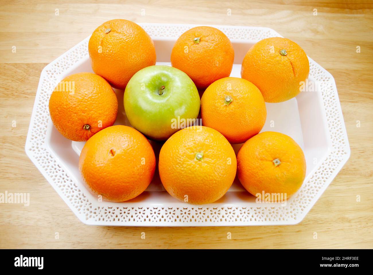 Multiple Oranges on a White Platter with One Green Apple Stock Photo ...