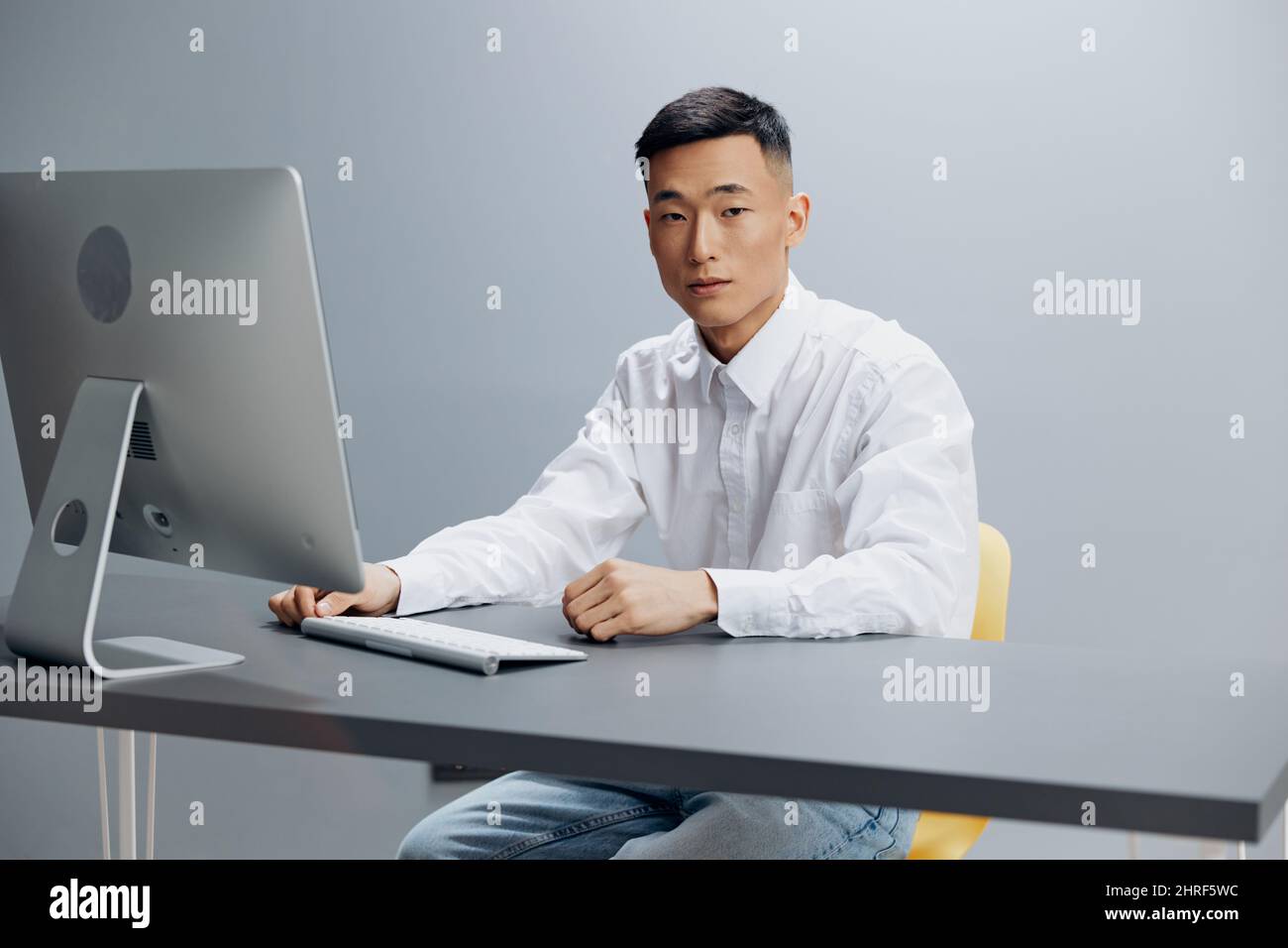 man sits at a computer in the office with a keyboard isolated ...