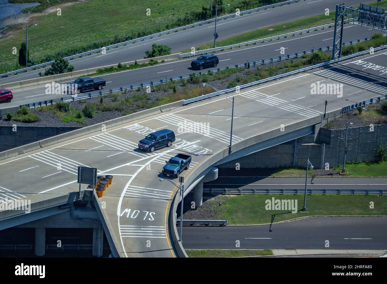 Aerial view of a blue vehicle exiting interstate while another passes ...