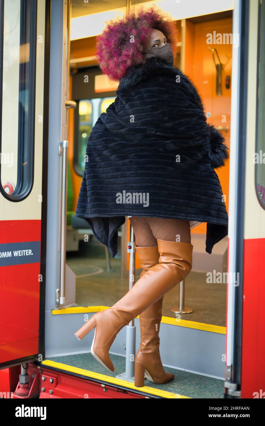 Red hair African woman posing for the camera while getting on the bus ...