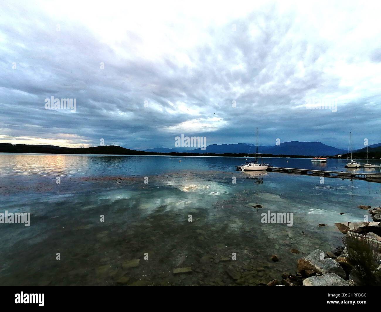 Breathtaking shot of the navy blue sea landscape with the small ships ...