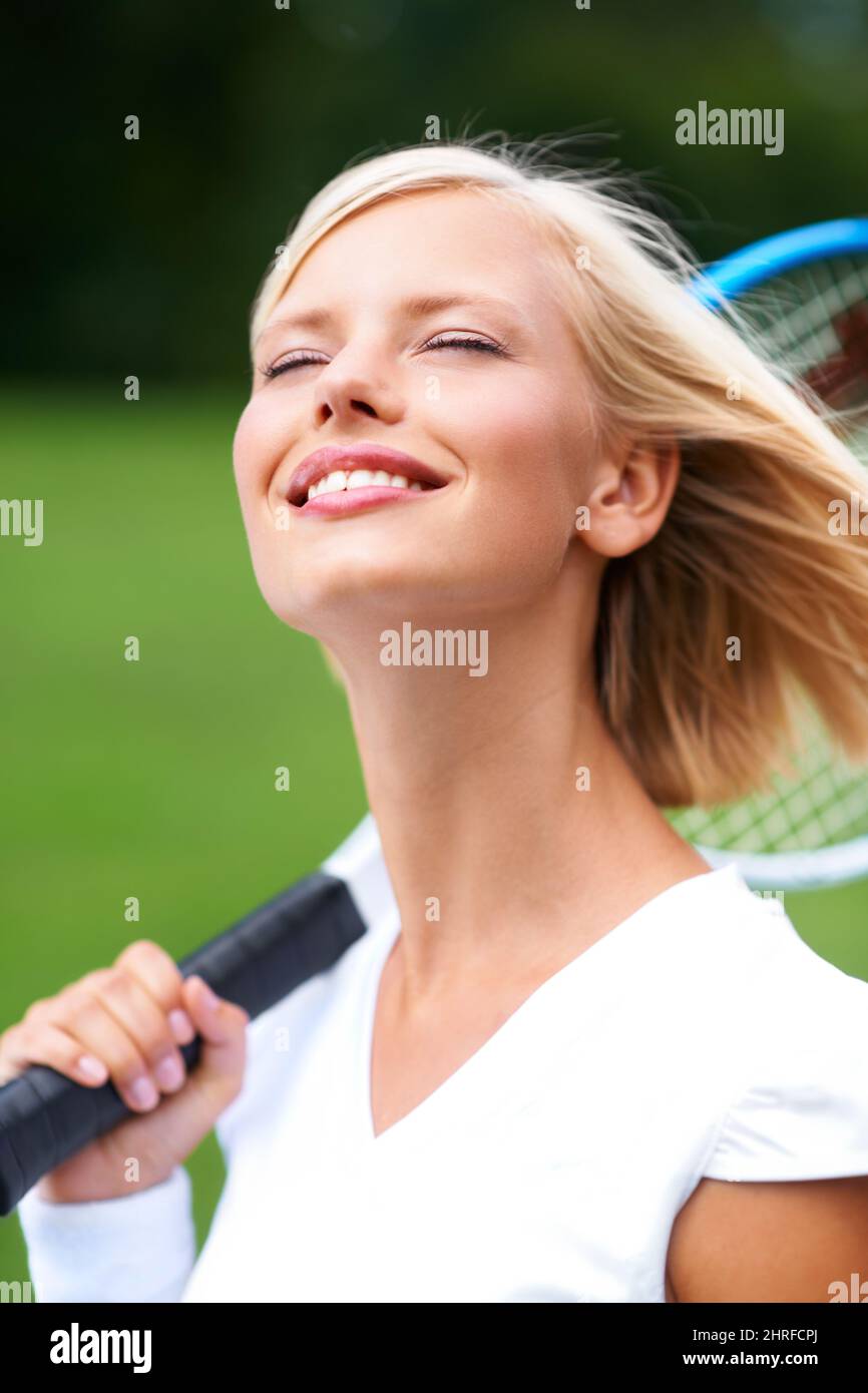 Enjoying the feel of the fresh air in her hair. A young tennis player ...