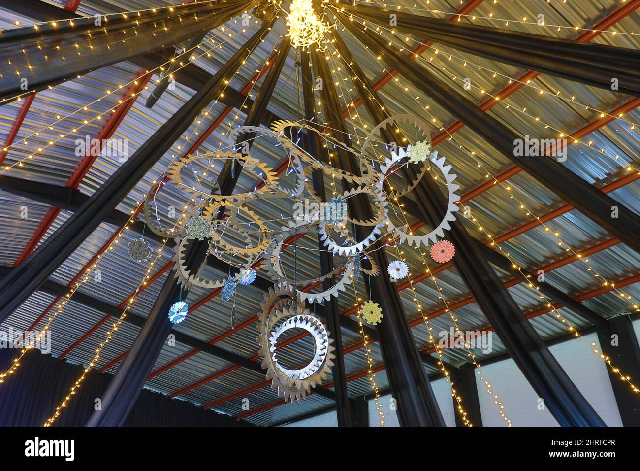 Low-angle shot of gears hanging from ceiling with led lights or fairy ...