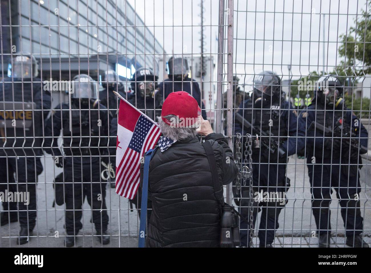 A tourist takes a photo of a rank of riot police outside in Quebec City ...