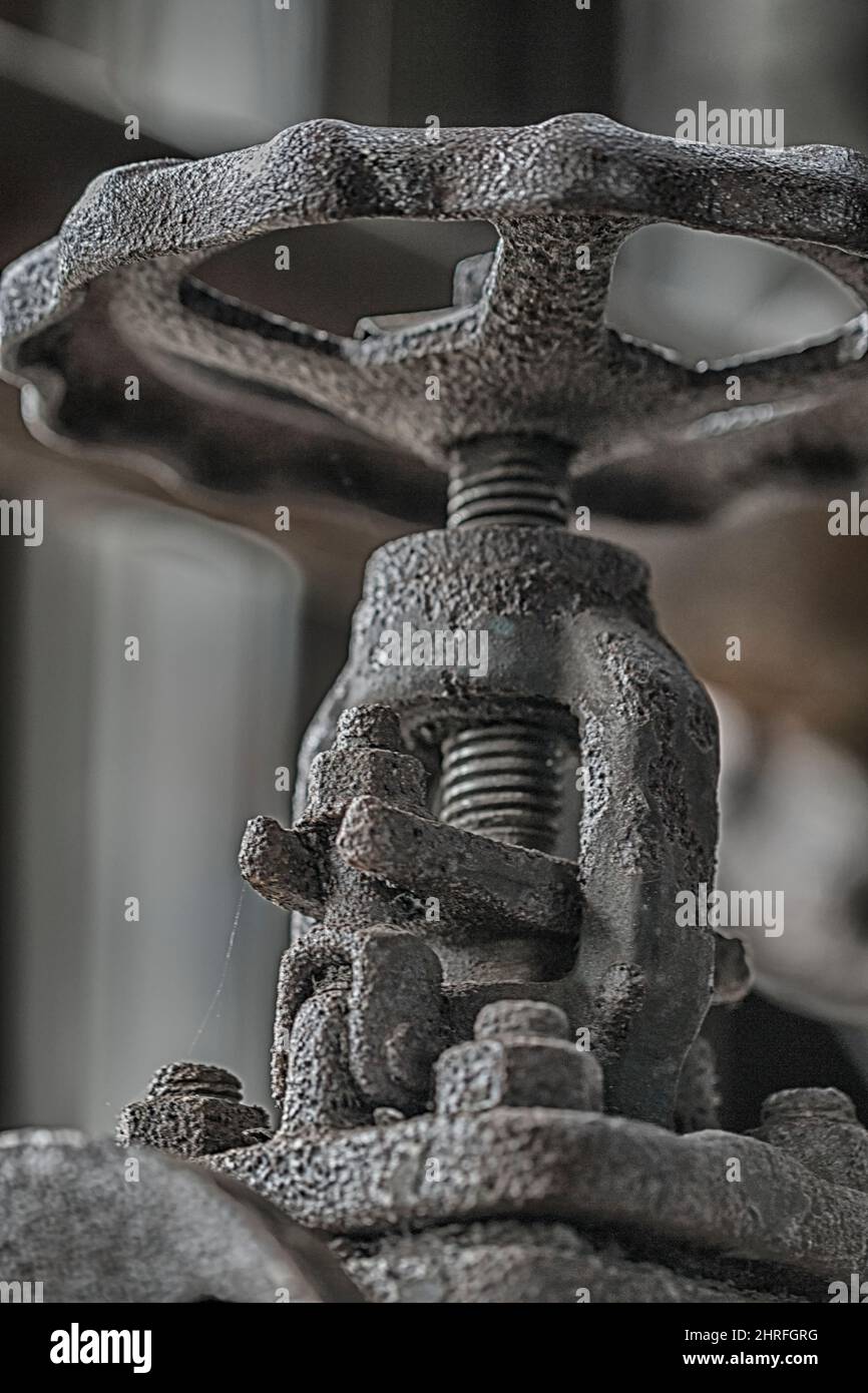 a close up of an old rusty valve in a decommissioned industrial plant ...