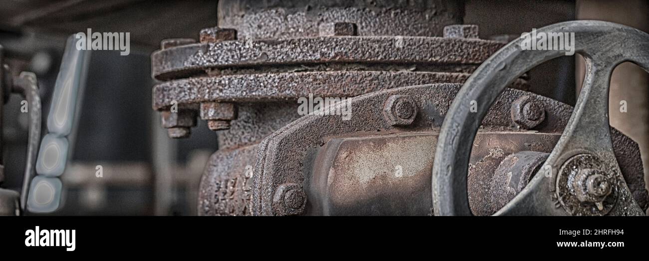 a close up of an old rusty valve in a decommissioned industrial plant ...