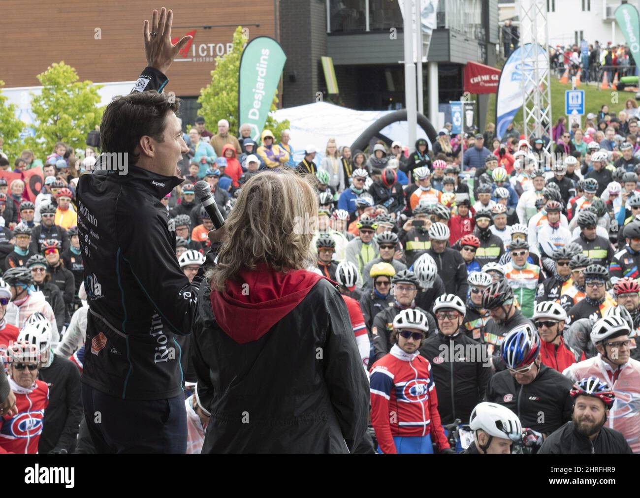 Prime Minister Justin Trudeau left, waves to cyclists at the start of ...