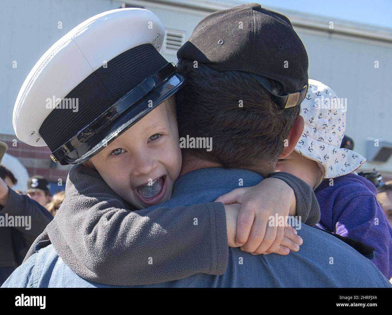 Five-year-old Michael Larkin embraces his dad, Petty Officer (second ...