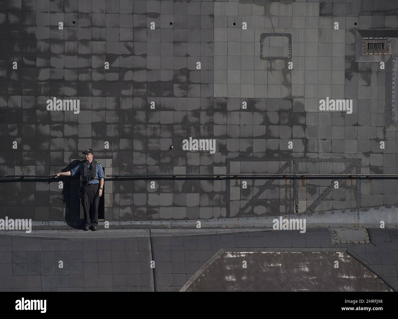 A sailor stands at the base of the conning tower on HMCS Windsor, one ...