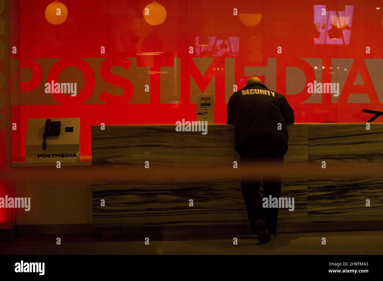 A security guard stands by the front reception desk at Postmedia's ...