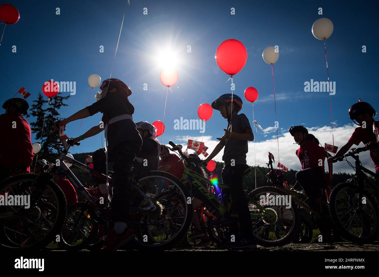 Children with balloons and Canadian flags on their bikes wait to ride ...