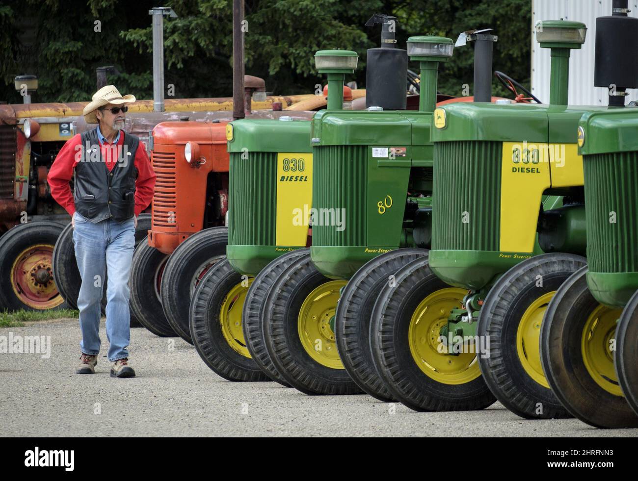 A farmer admires vintage tractors on display during Canada Day ...