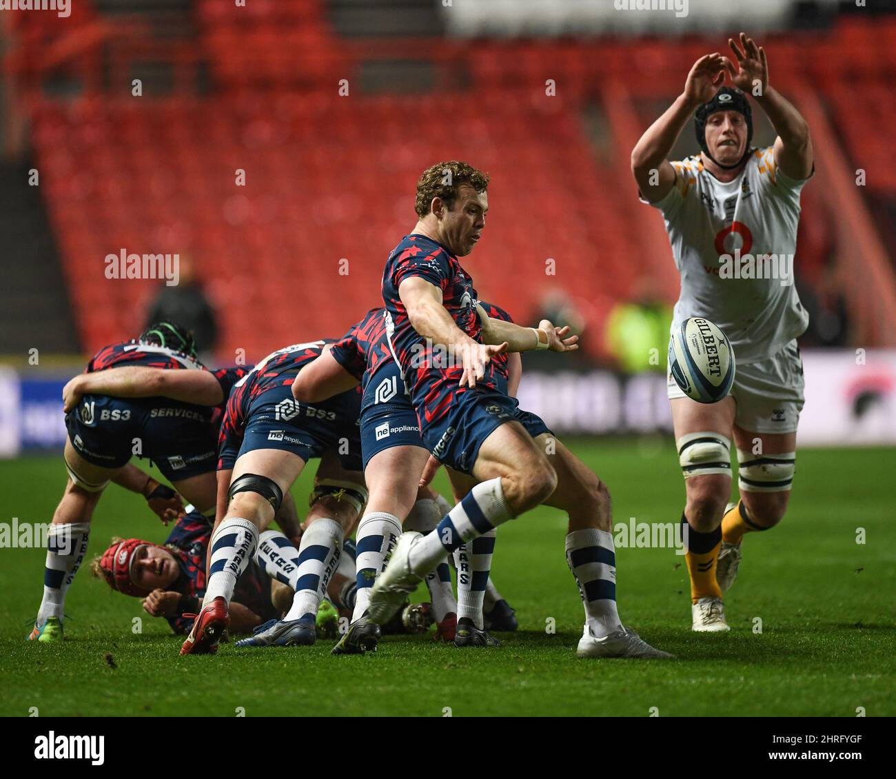 Theo Strang of Bristol Bears, clears the ball under pressure from James ...