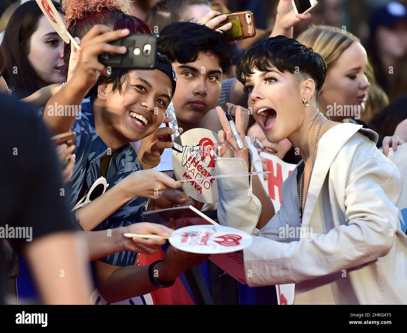 Halsey poses for photos with fans as she arrives on the red carpet at ...