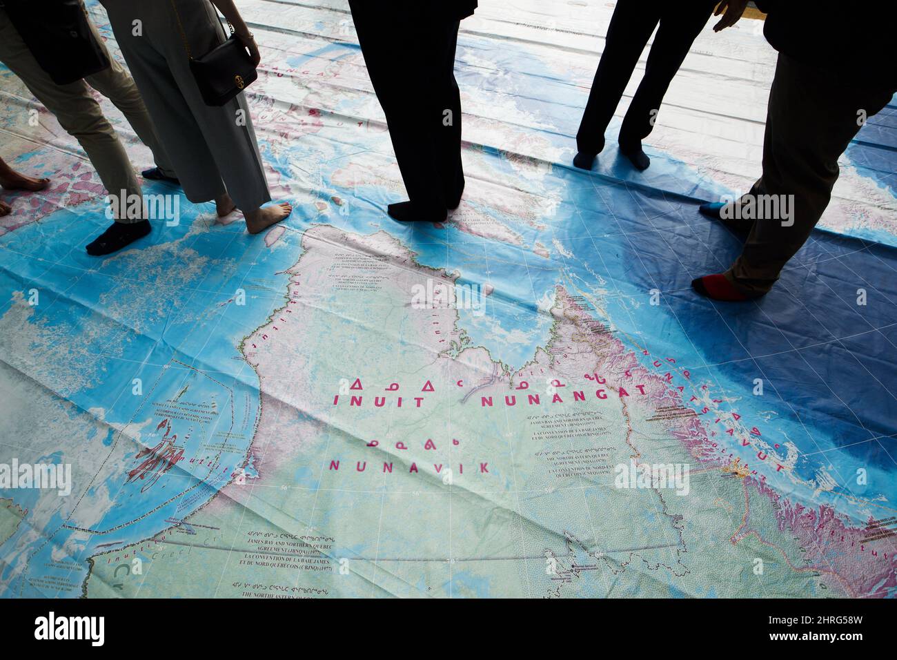 People stand on a giant map from the Indigenous Peoples Atlas of Canada ...