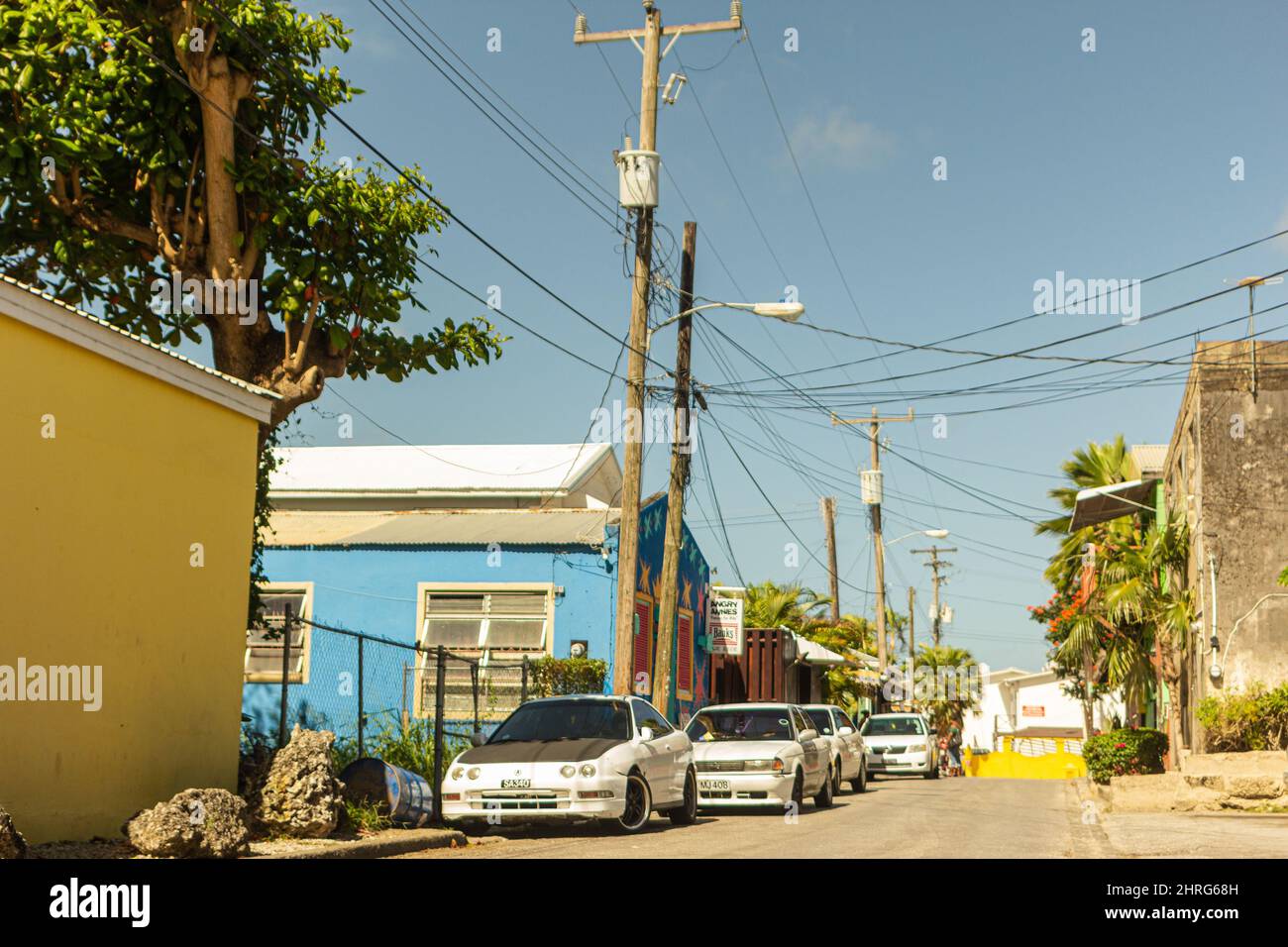View of a Street in Whole Town in Barbados with cars parked outside a blue house Stock Photo - Alamy