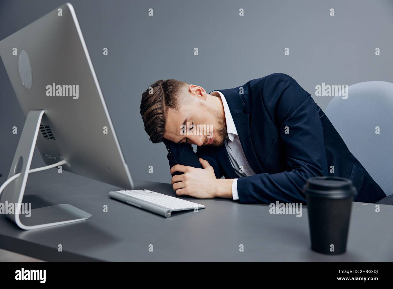 manager sitting at a desk in front of a computer Gray background Stock ...