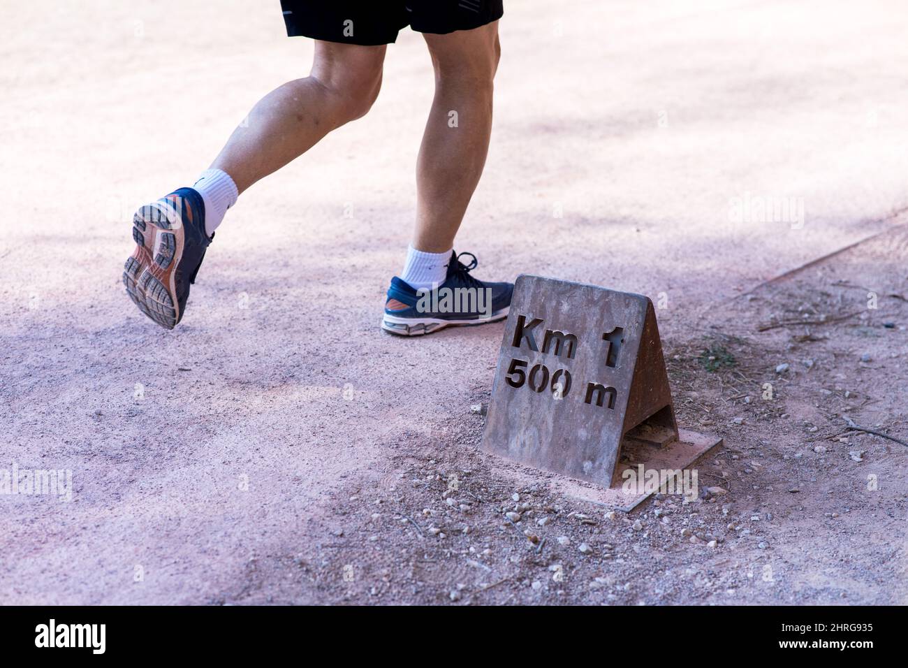 Legs of a fit male running a marathon near the 1km sign Stock Photo - Alamy