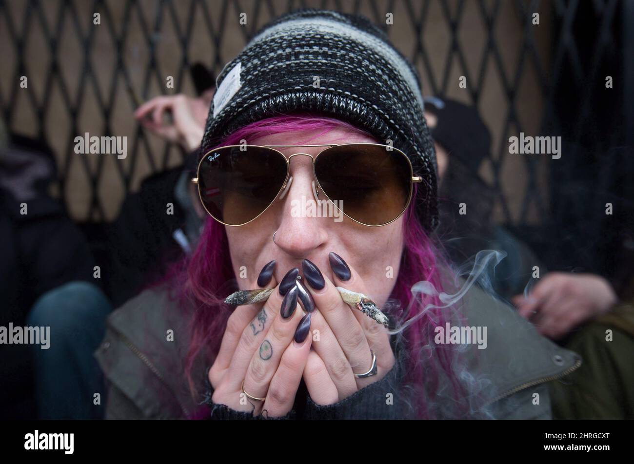 A woman smokes two joints during a sit-in as police officers raid the ...