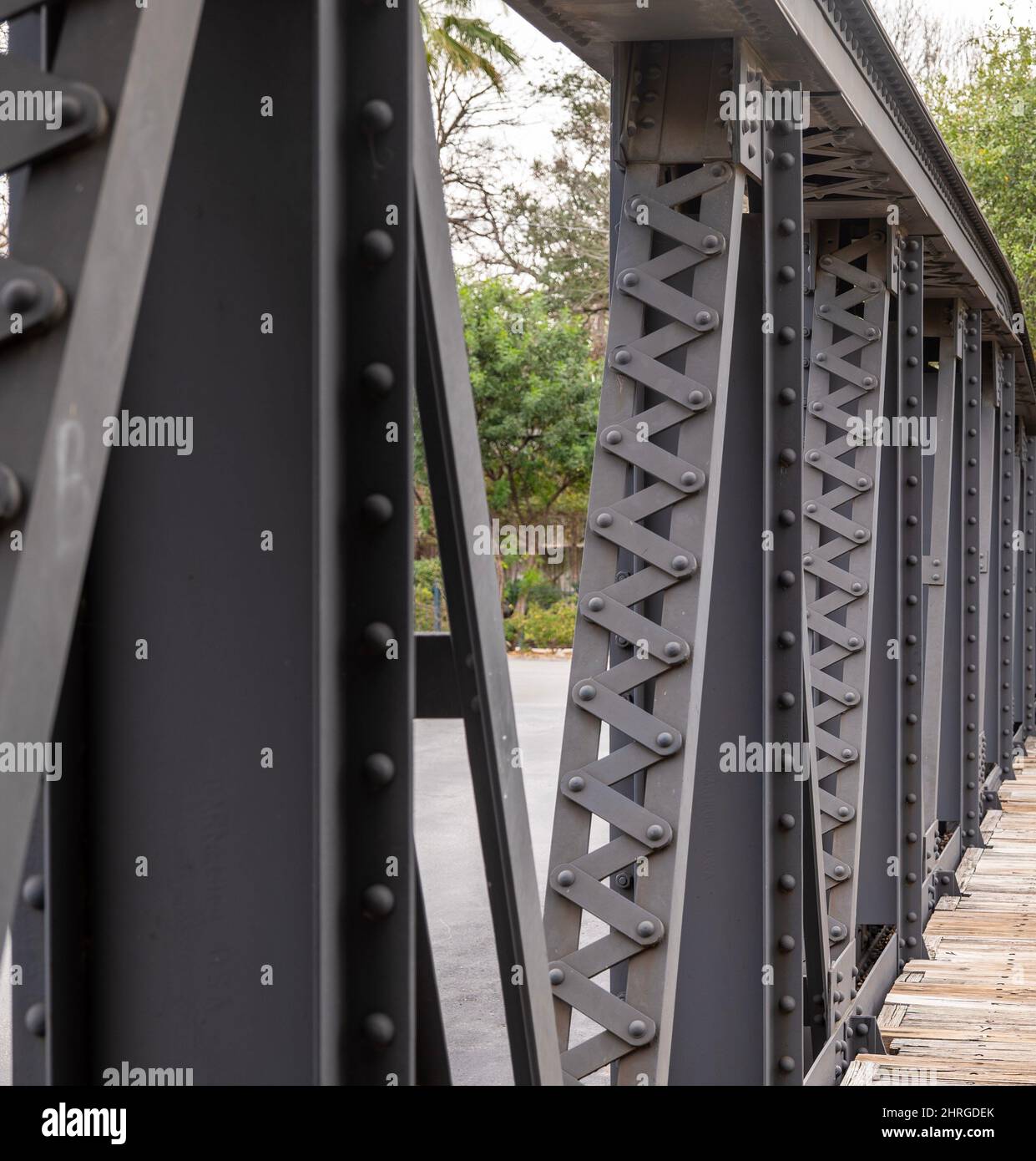 Iron truss bridge beams painted gray with many bolts, in closeup photo ...