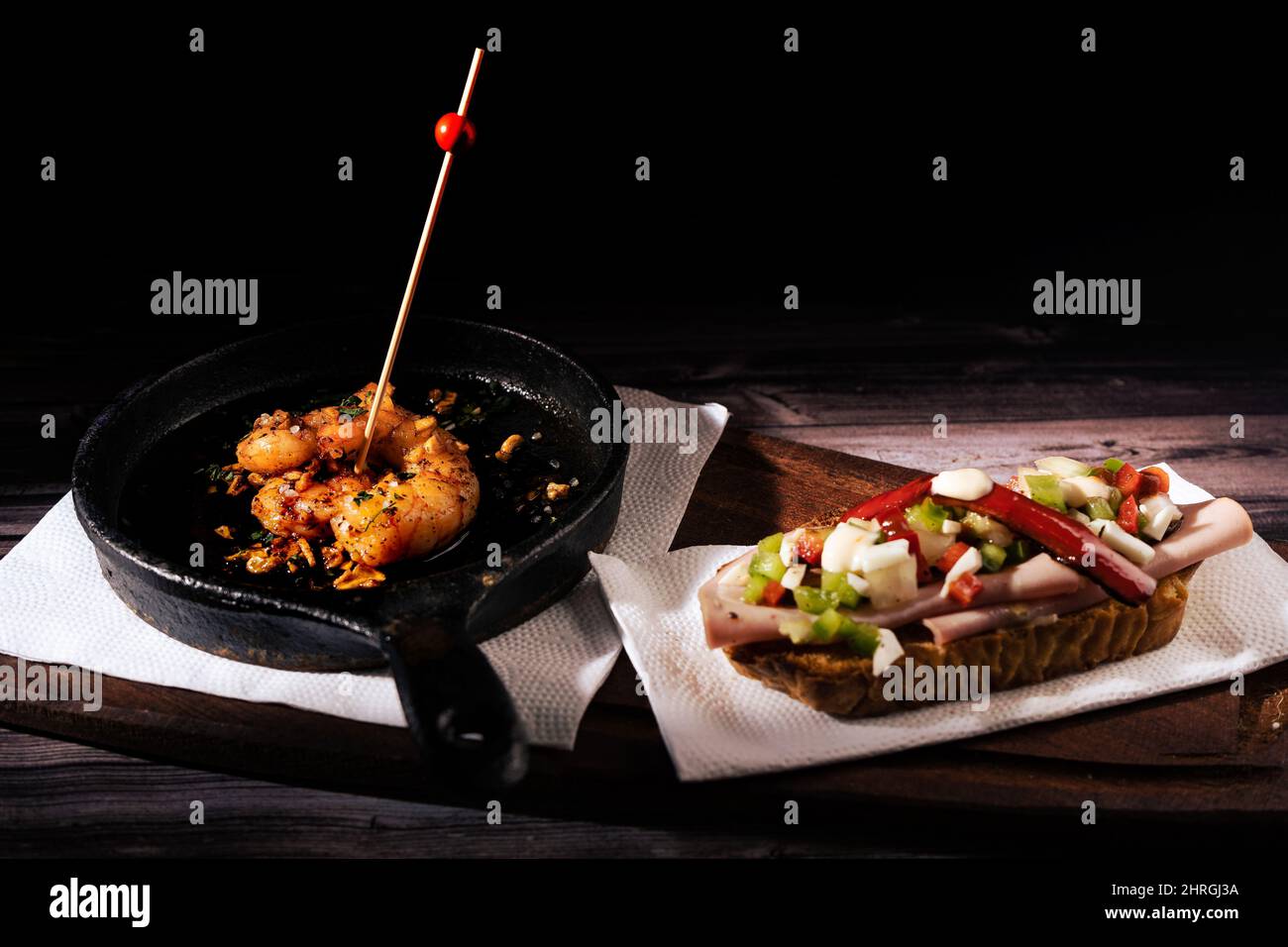 Two different typical Spanish tapas on a rustic table with a dark ...