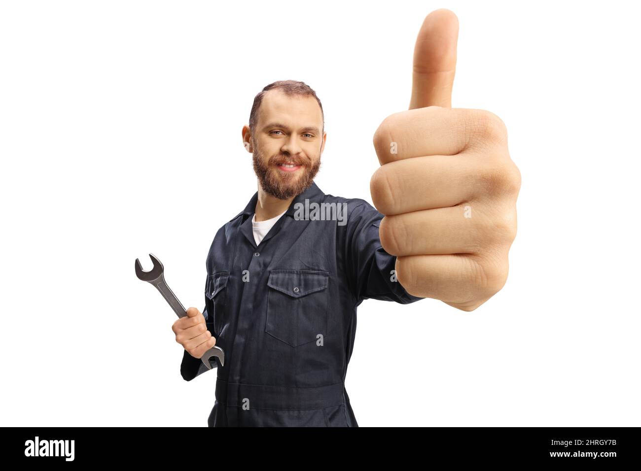 Mechanic posing with a wrench in his hand and gesturing thumbs up ...