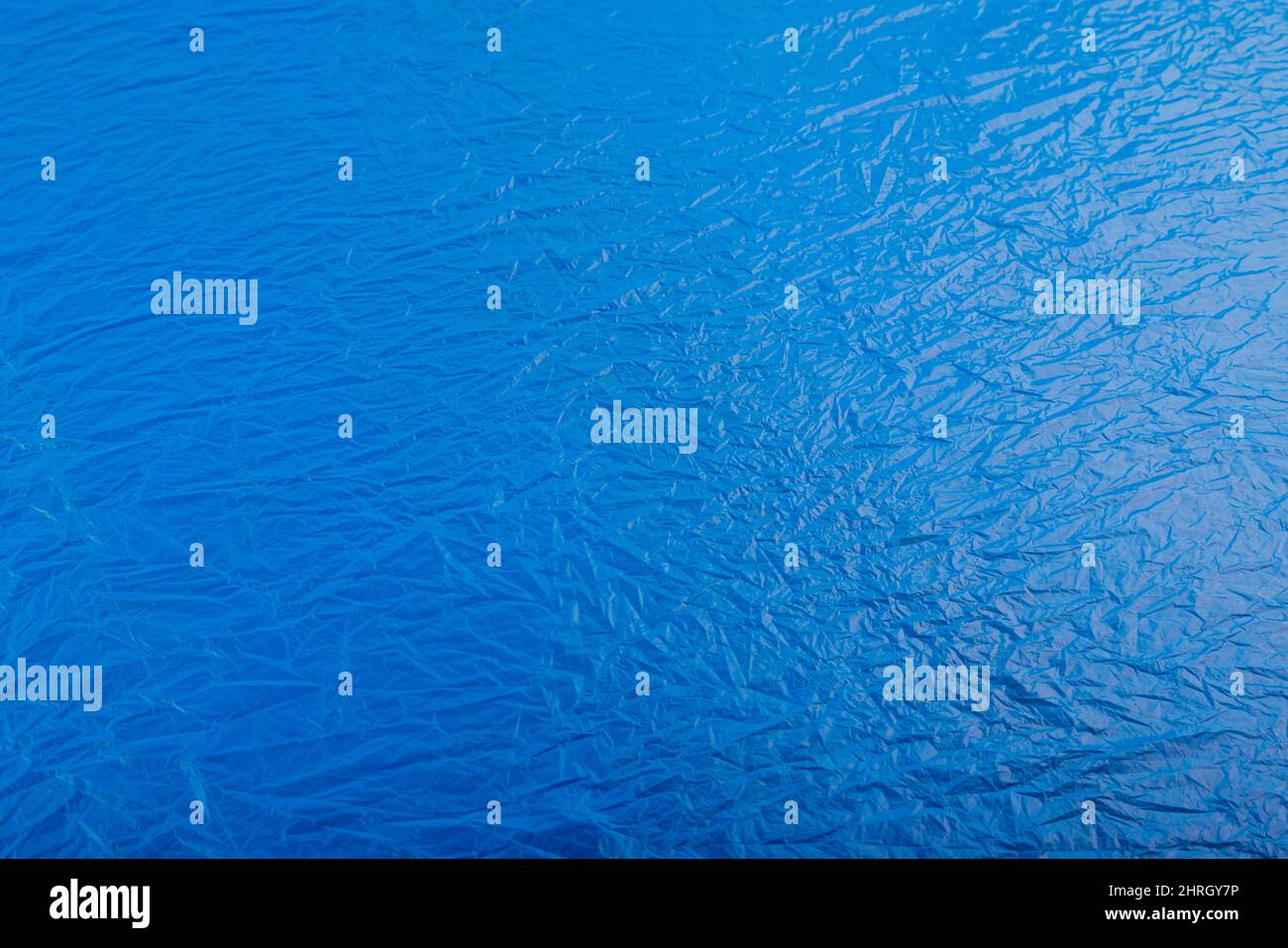 full frame flat background and texture of crumpled blue plastic film ...