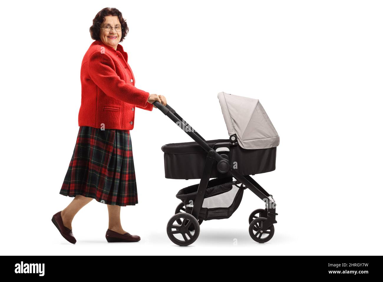 Full length profile shot of a happy elderly woman walking and pushing a ...