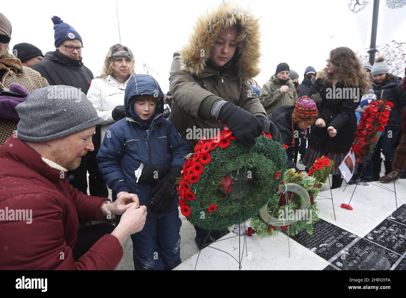 Poppies are placed on wreaths at a cenotaph during a Remembrance Day ...