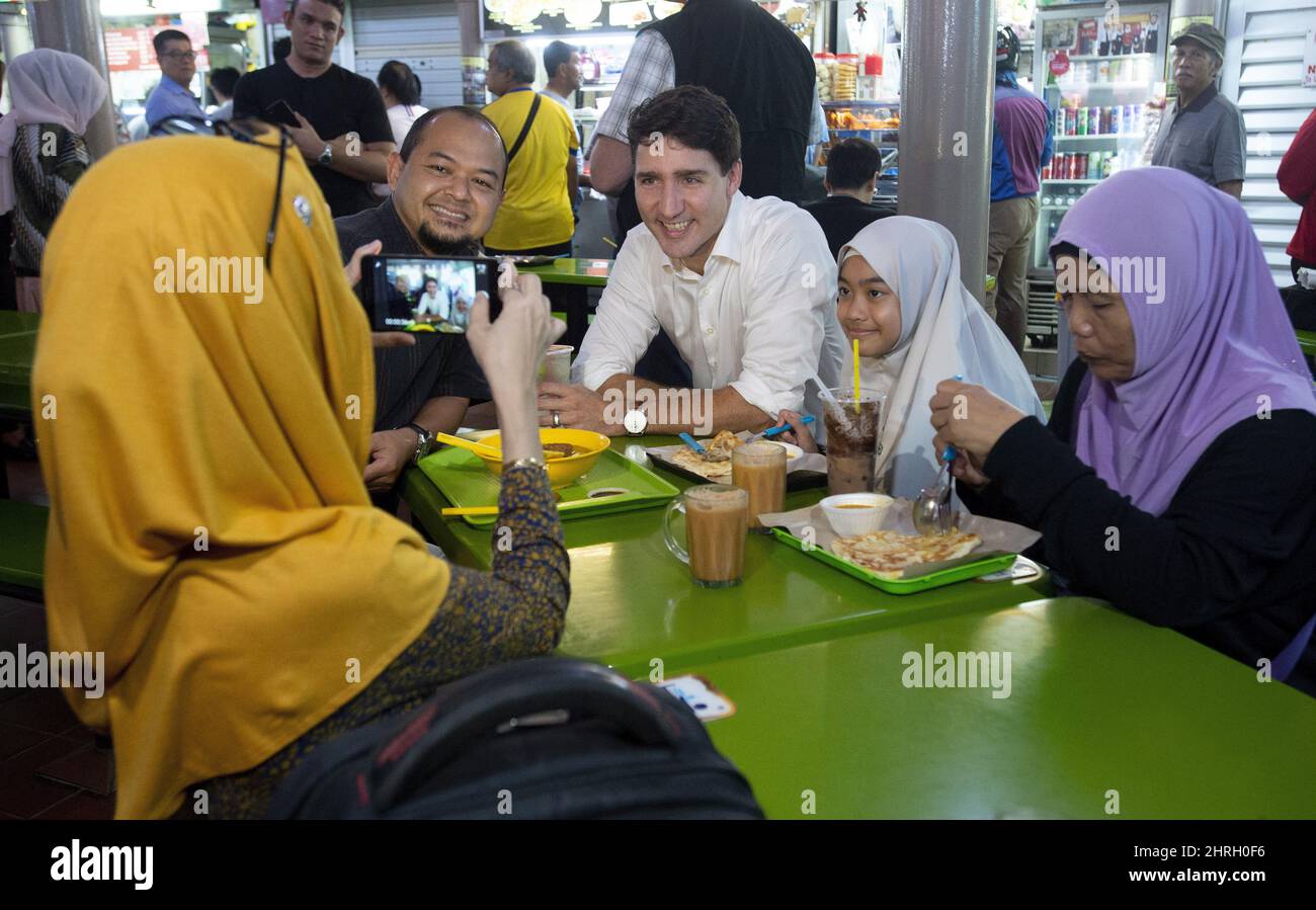A woman takes a photo of Canadian Prime Minister Justin Trudeau and her ...