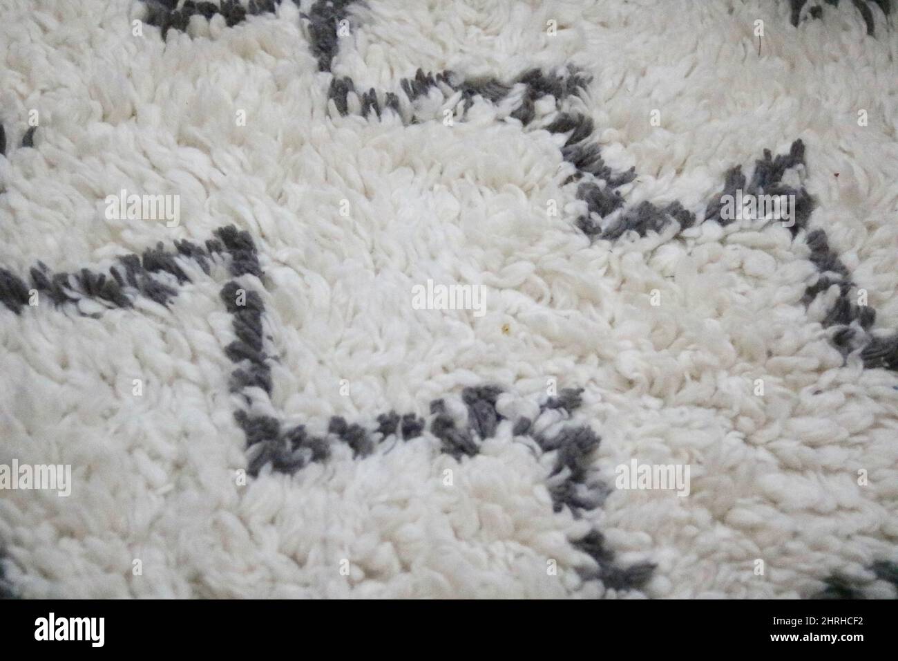 Full frame interior background of white shaggy rug with zig zag pattern ...