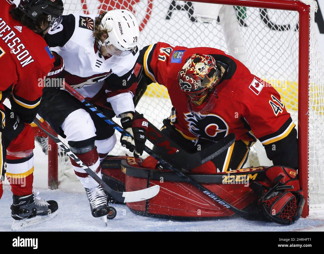 Arizona Coyotes' Mario Kempe, centre, of Sweden, tries to get the puck ...
