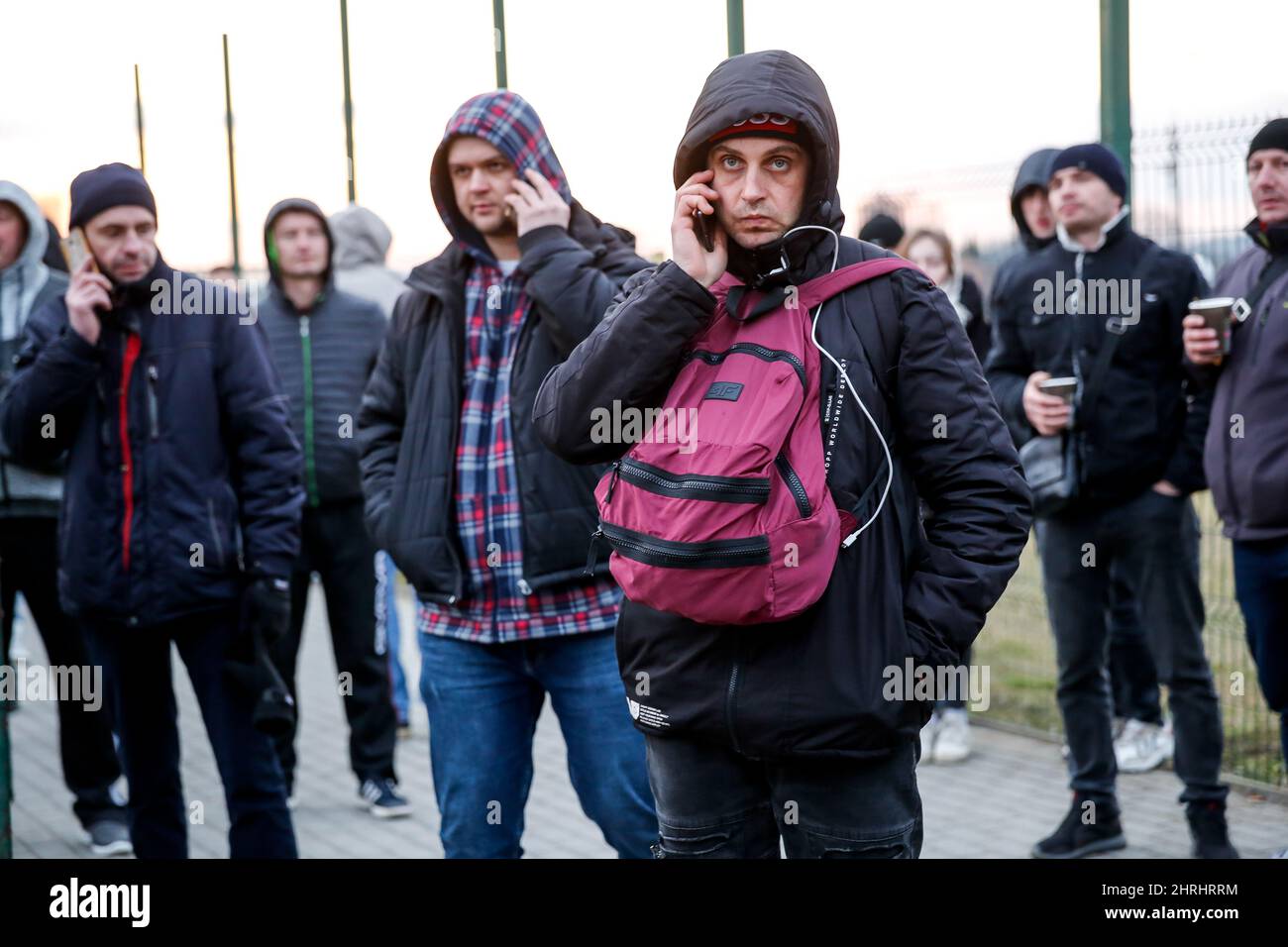 Ukrainian men wait by the border passage for an arrival of their loved ...