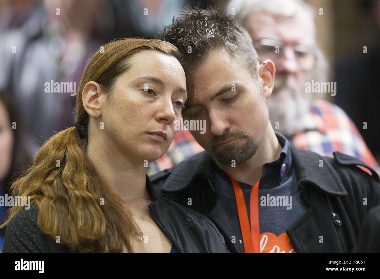 Samantha Graham and Sean Graham listen to a speech while standing in an ...