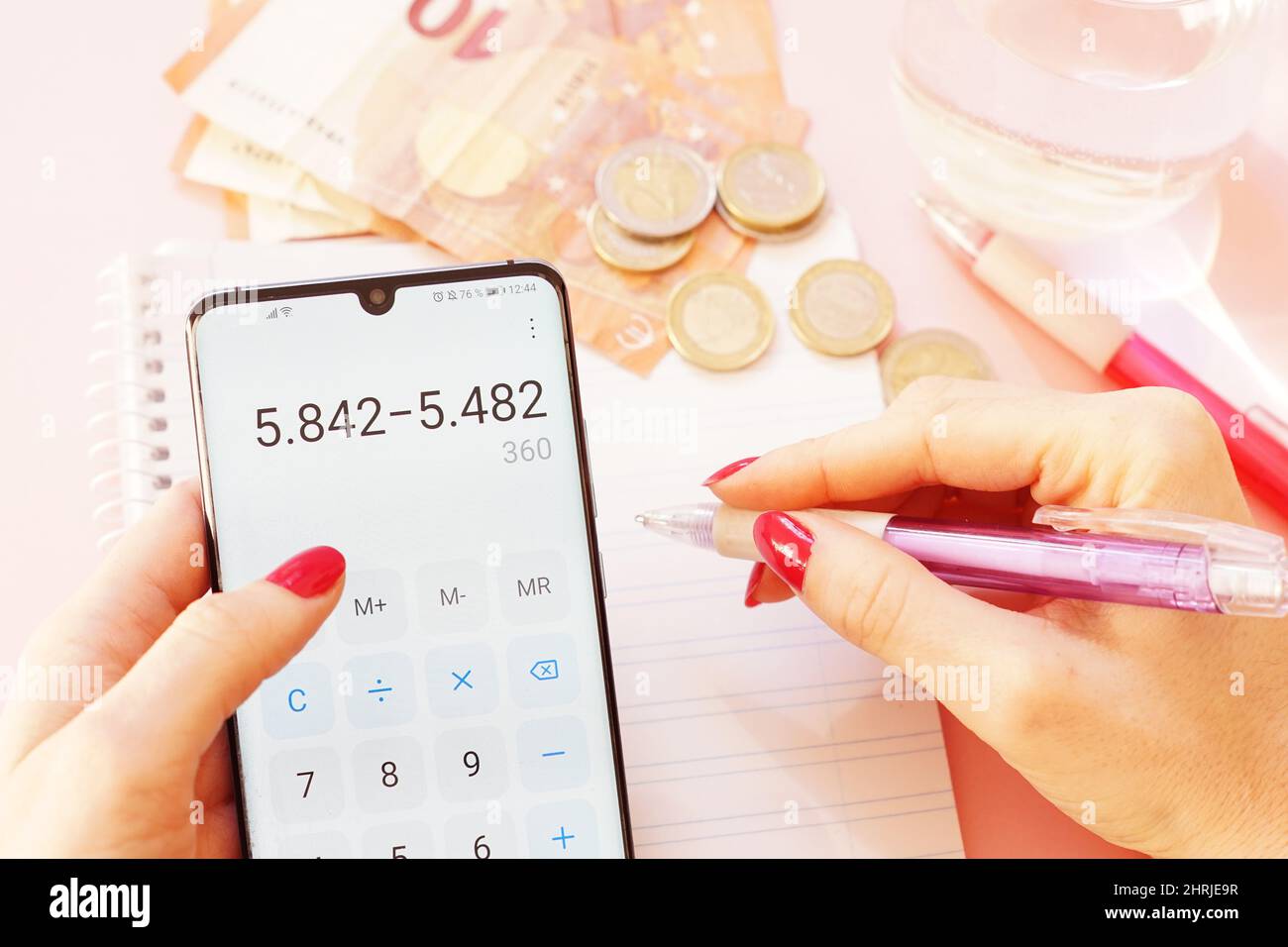 Girl calculating with smartphone and coins in the background Stock ... Girl calculating with smartphone and coins in the background Stock ...