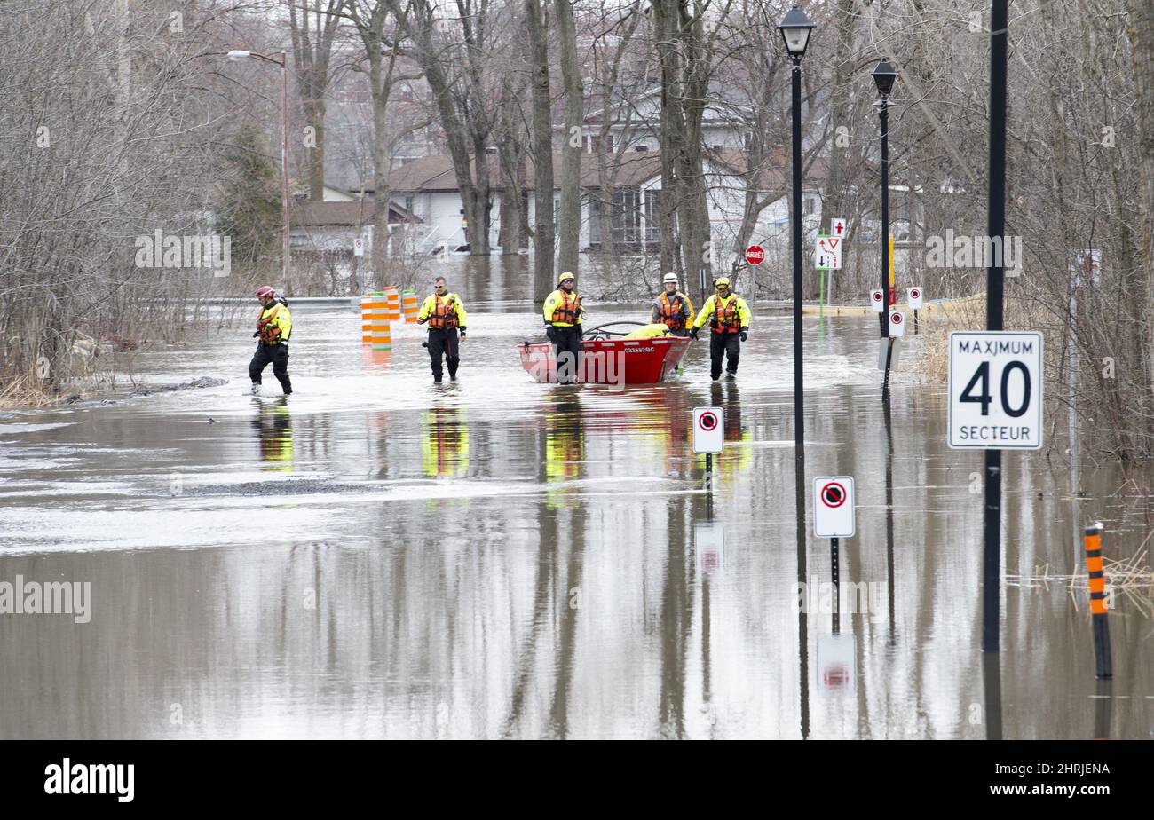Firemen patrol a flooded neighbourhood in the Ile-Bizard borough of ...