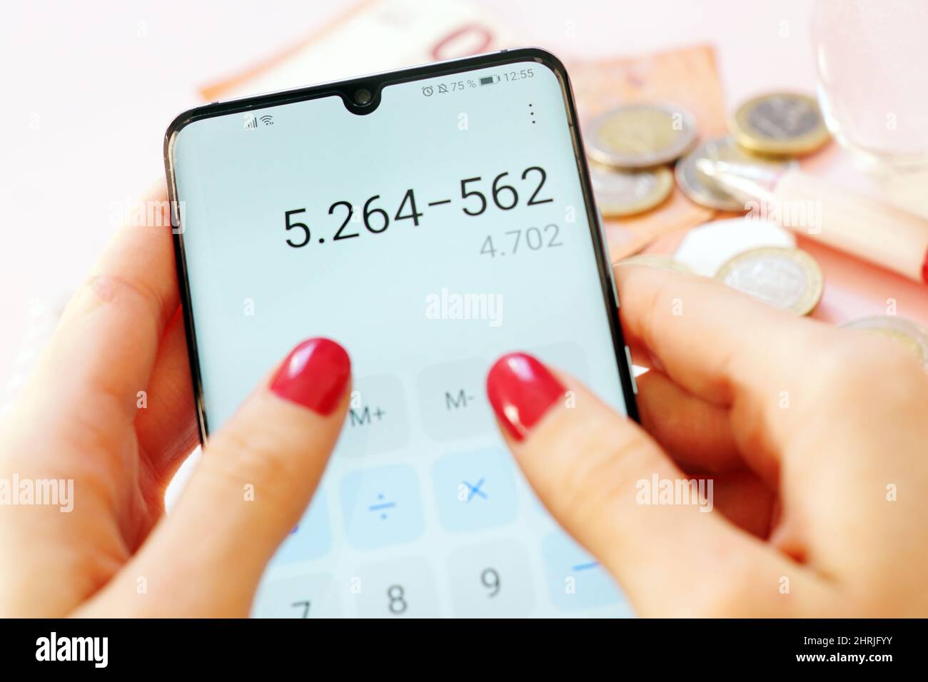 Girl calculating with smartphone and coins in the background Stock ...