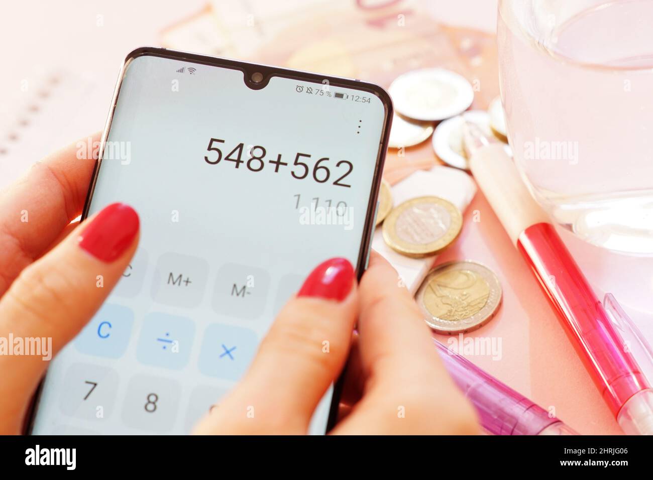 Girl calculating with smartphone and coins in the background Stock ... Girl calculating with smartphone and coins in the background Stock ...