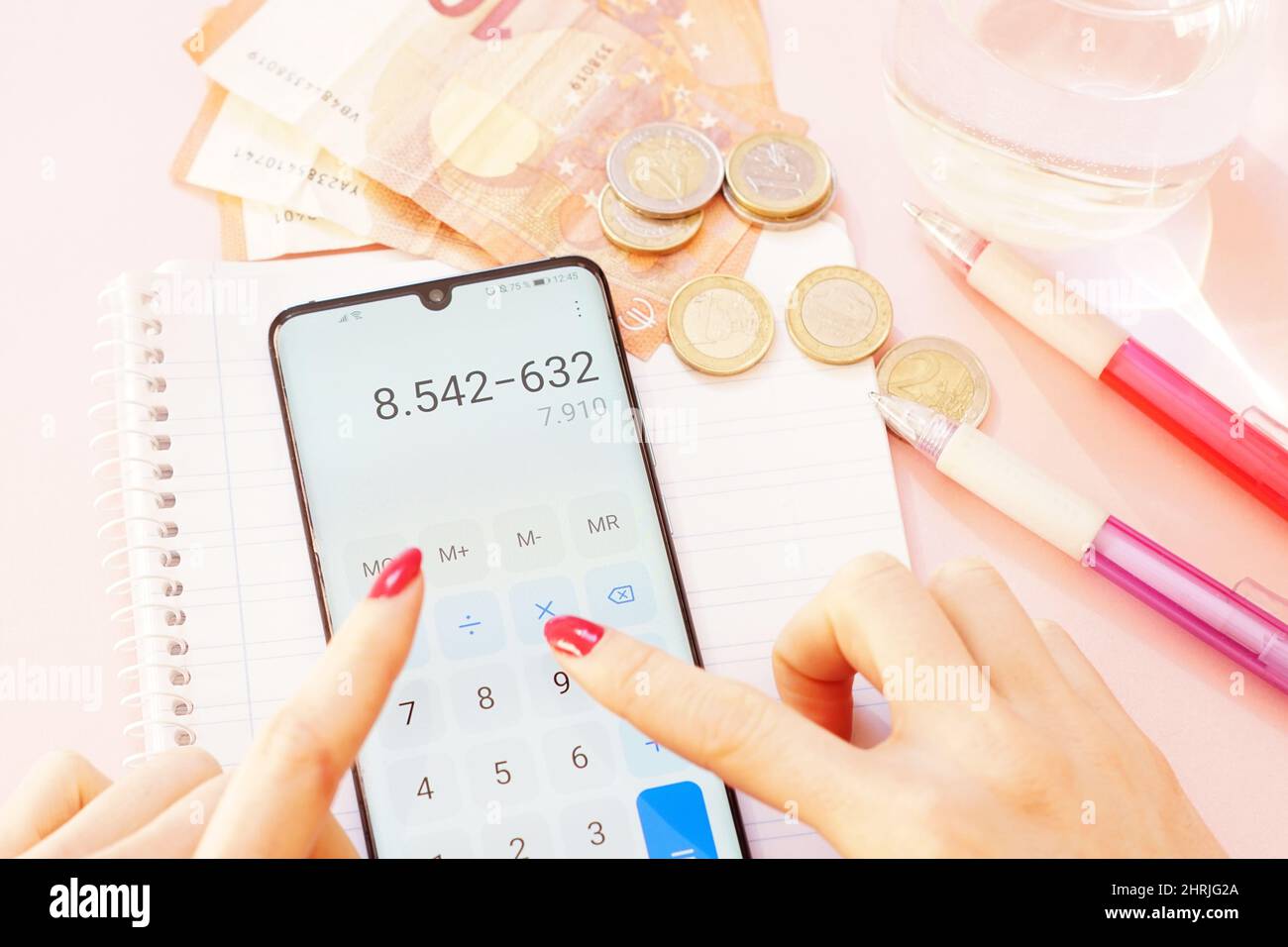 Girl calculating with a smartphone and coins in the background Stock ... Girl calculating with a smartphone and coins in the background Stock ...