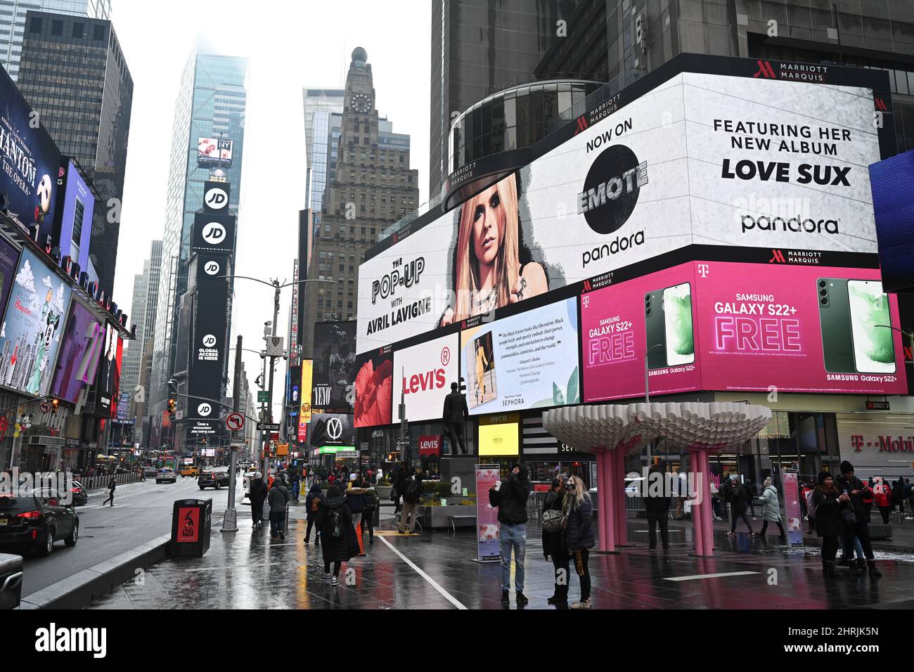 People walk in Times Square as cold weather causes icing on February 25 ...