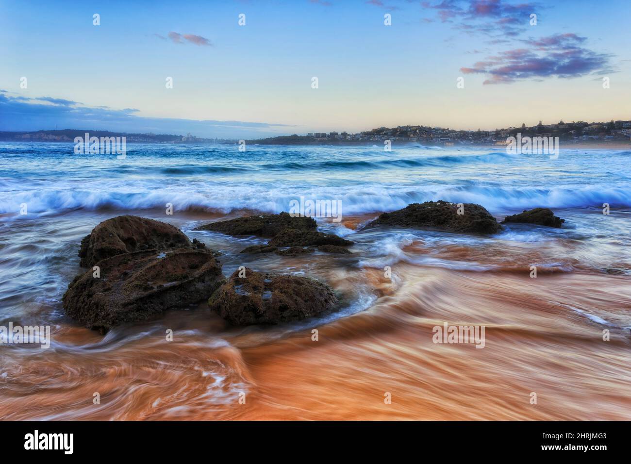 Scenic seascape sunrise of Sea Curl Curl with grey rocks group Stock ...