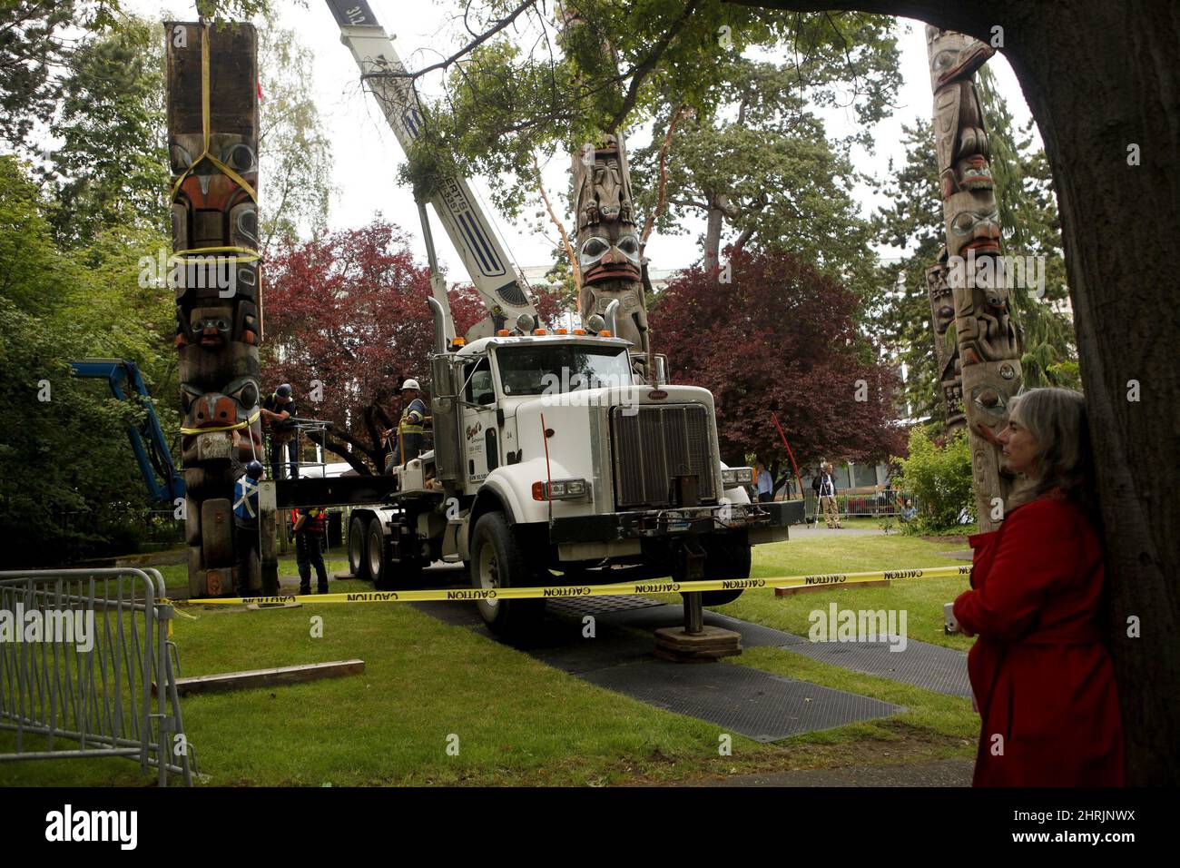 Workers prepare the 27-foot cedar mortuary pole replica carved by Mungo ...