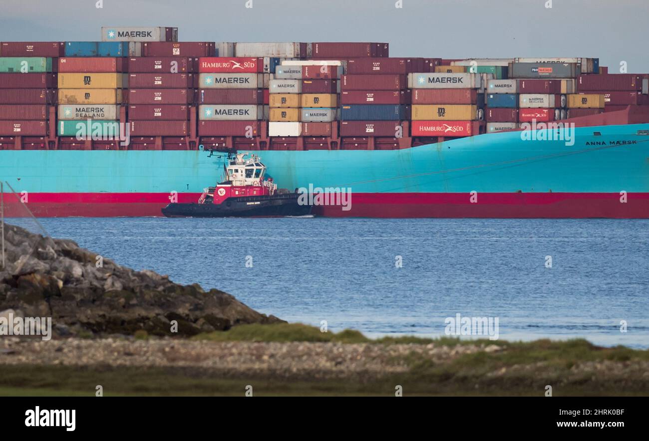 A tugboat guides the Anna Maersk container ship, carrying 69 containers ...