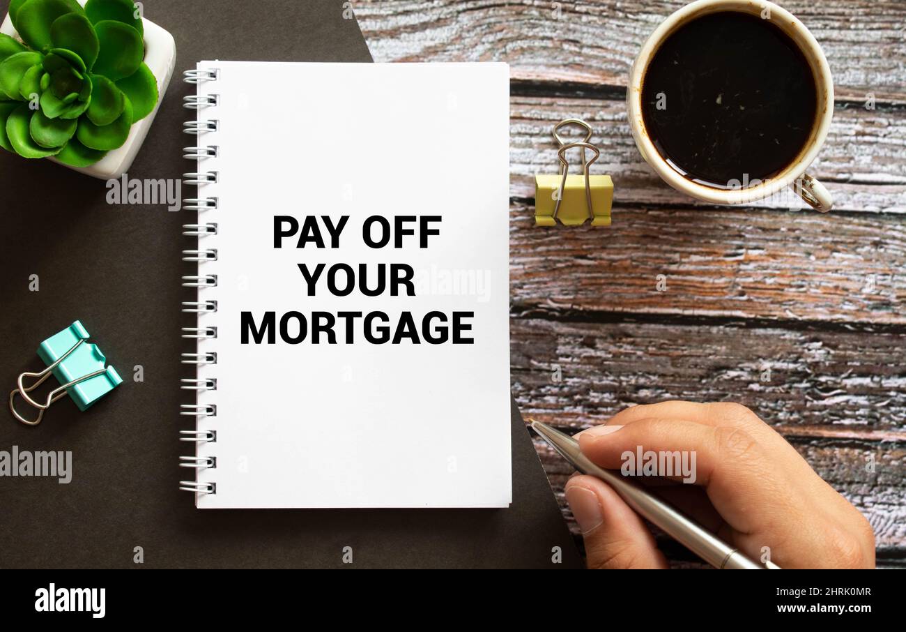 Closeup on businessman holding a card with PAY OFF YOUR MORTGAGE ...