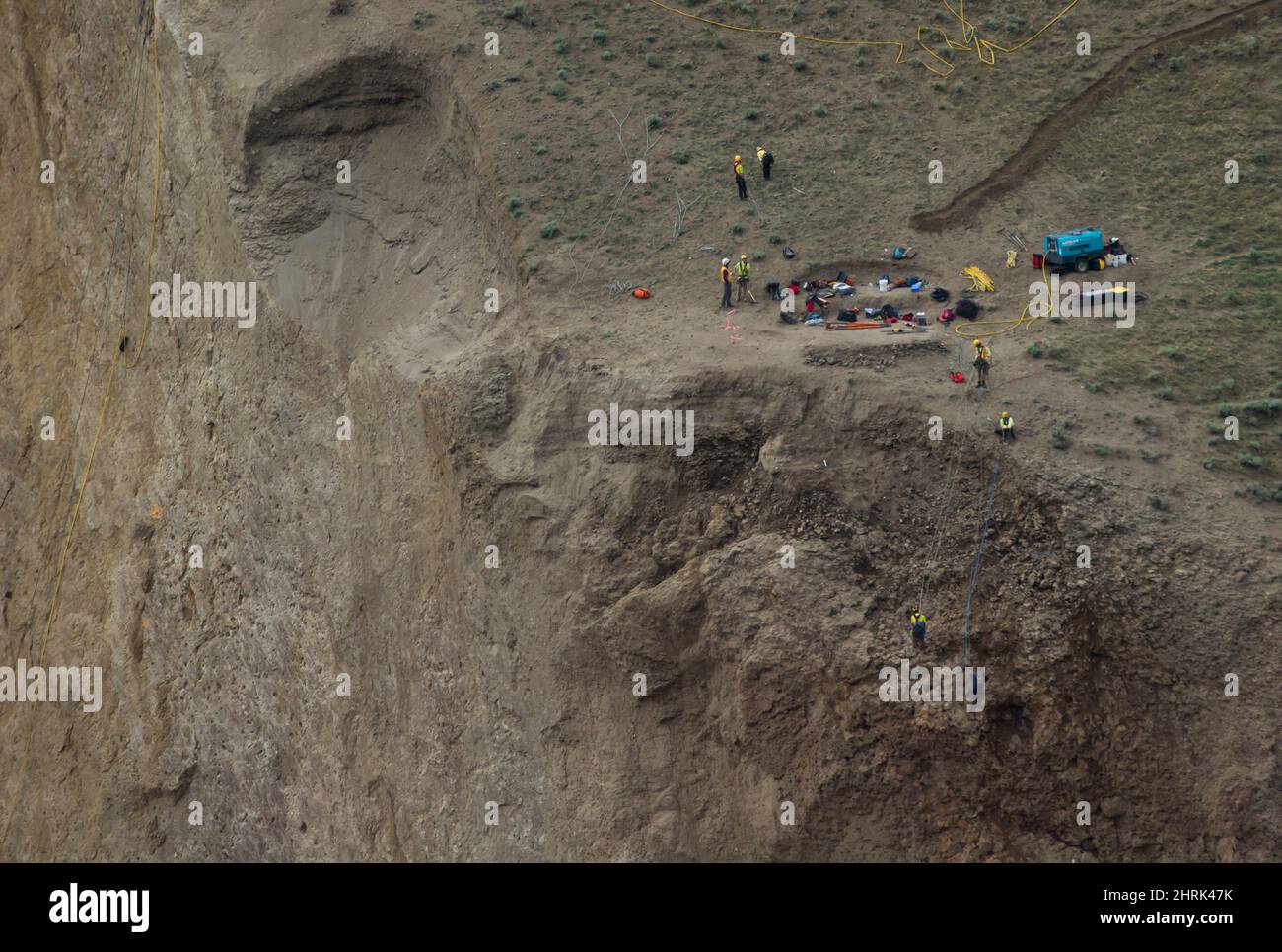 Rock scalers are seen on the cliff at the site of a massive rock slide ...